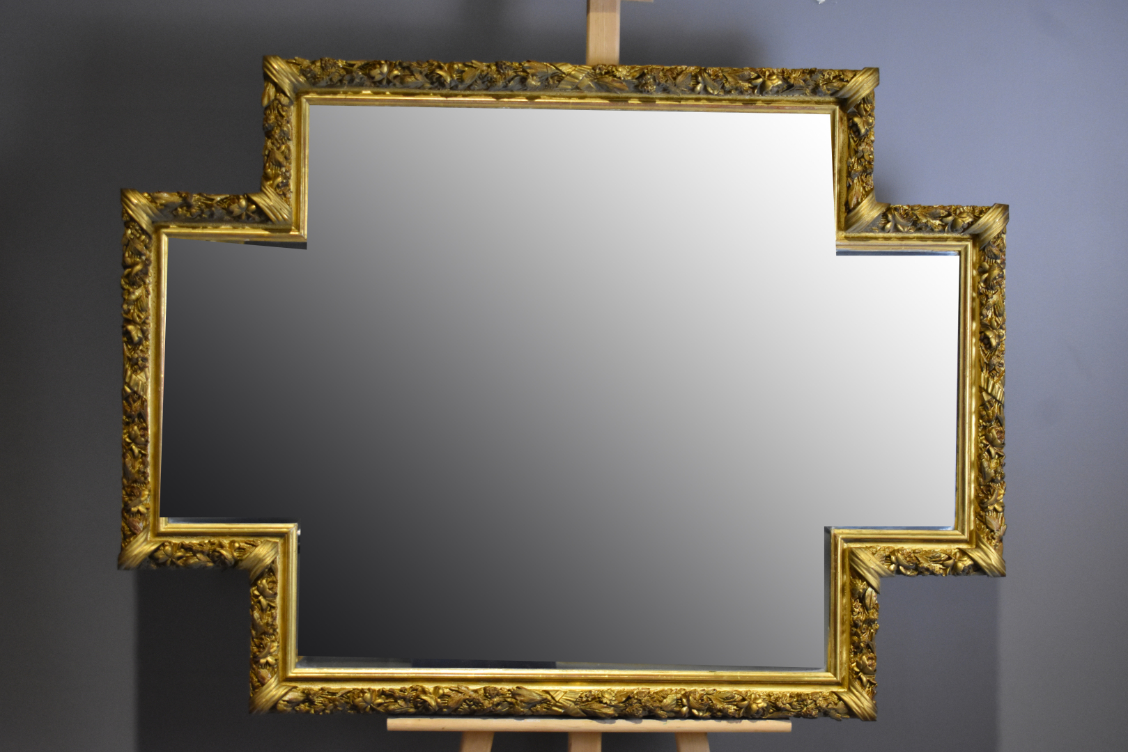 Miroir en forme cruciforme en bois sculpté doré à décor d'une guirlande ...